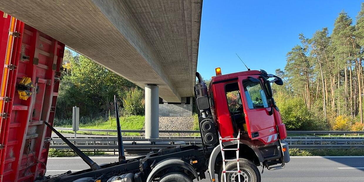 Laster bleibt auf Autobahn mit Ladefläche an Brücke hängen